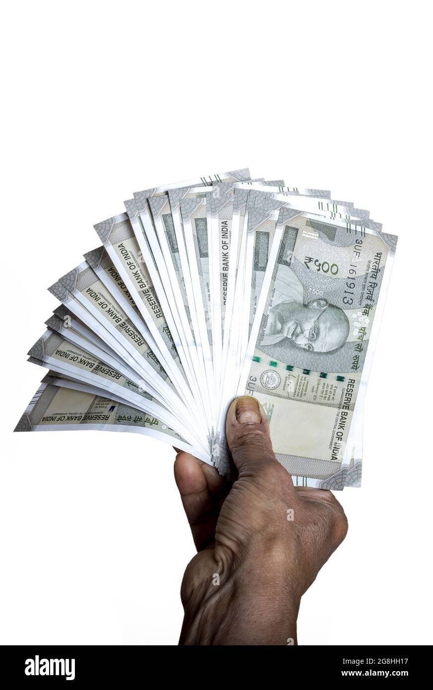 Vertical shot of a hand holding a stash of Indian rupee bills on an ...