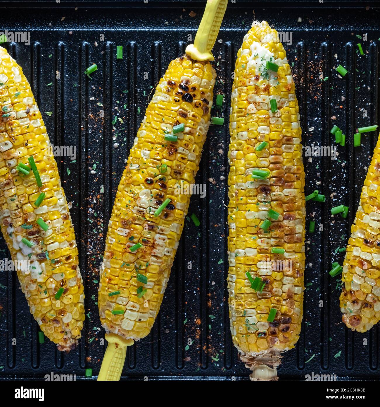 Top down view of ears of corn on the cob garnished with seasonings and ...