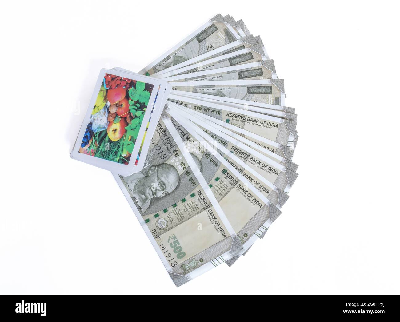 Stash of Indian rupee bills with a stack of playing cards on an ...