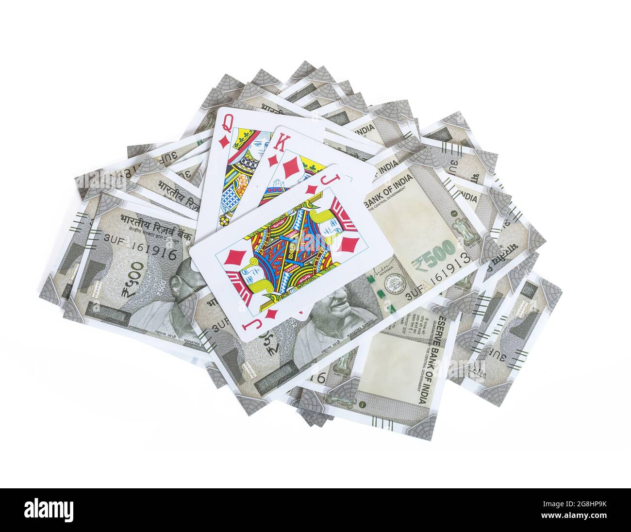 Top view of a heap of Indian rupee bills with playing cards on top of ...