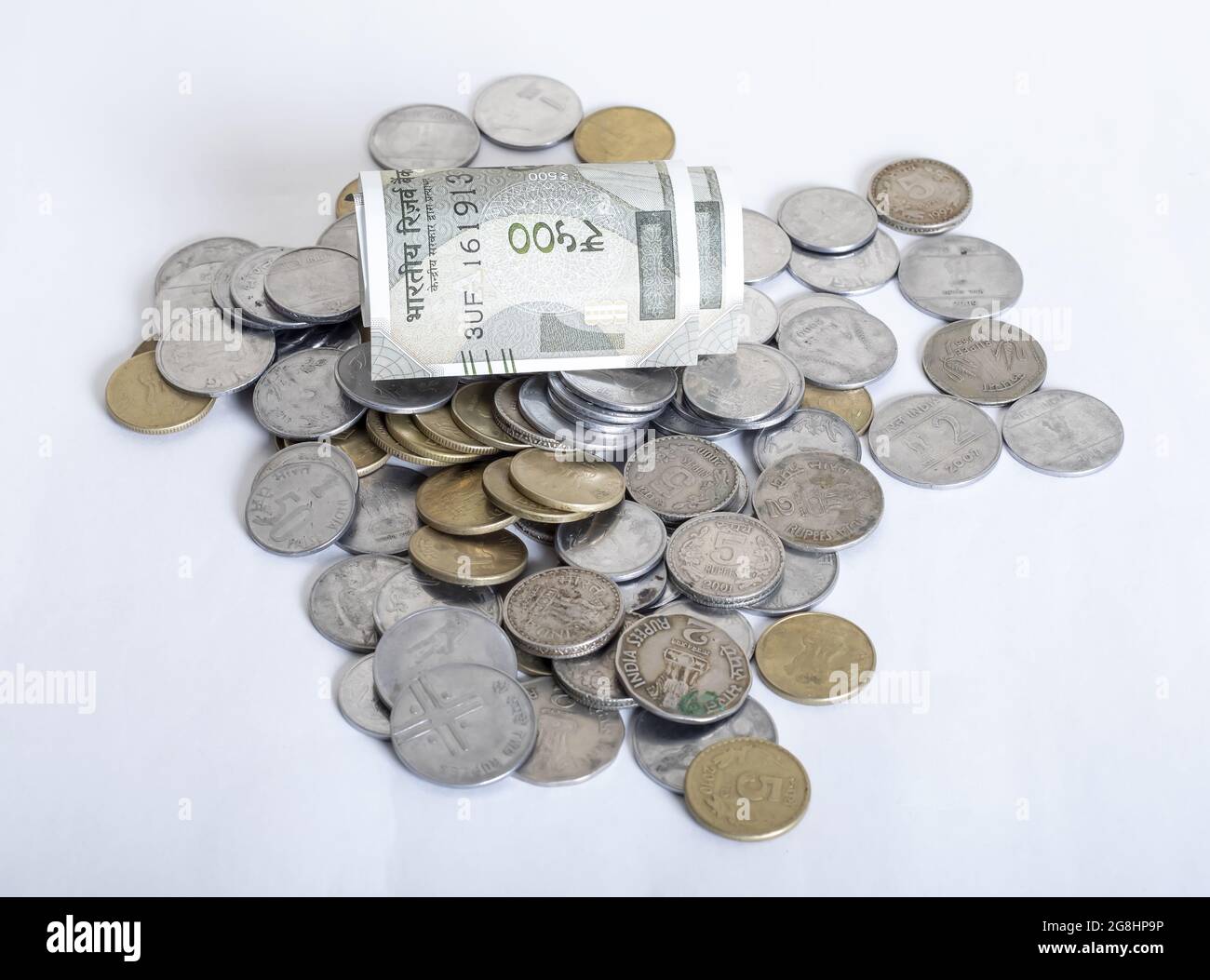 Closeup of a pile of Indian rupee coins with bills on a white isolated ...
