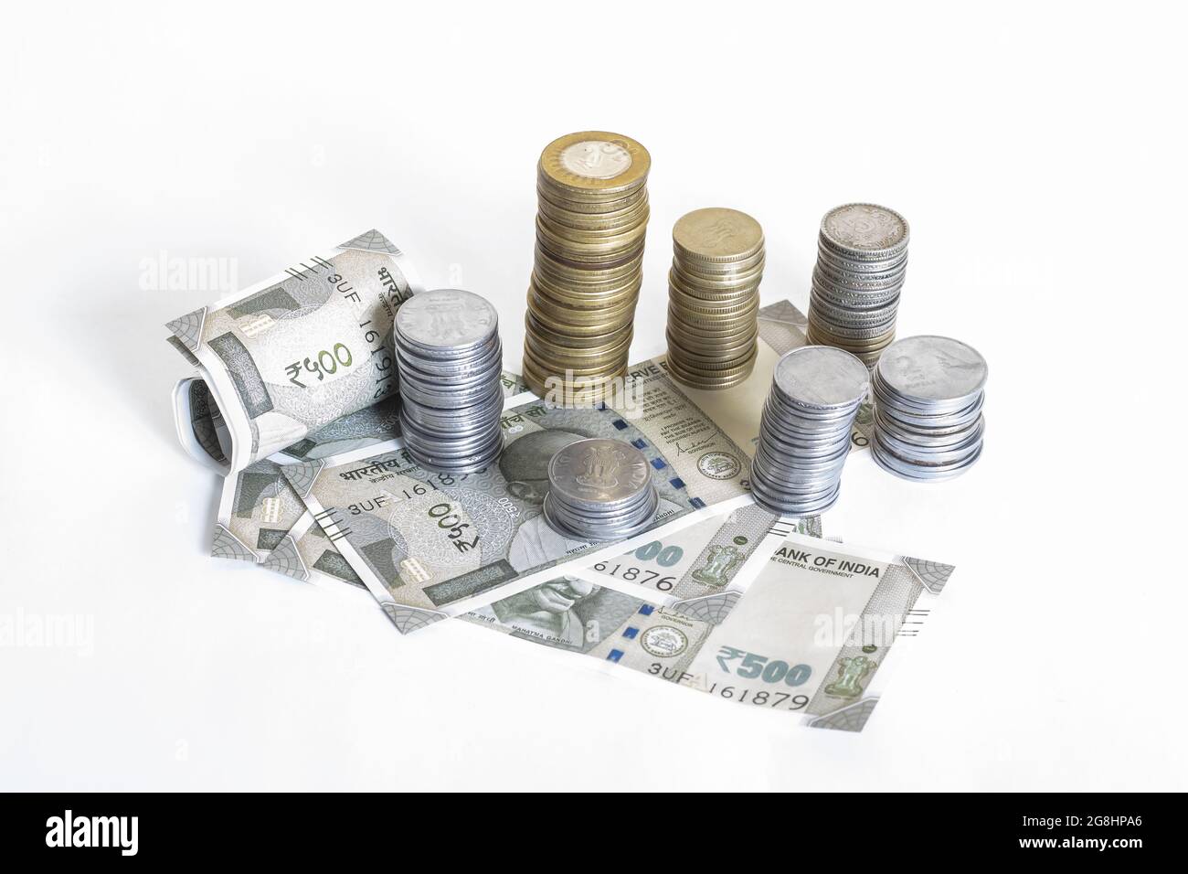 Isolated white background with stacks of Indian coins on top of 500 ...