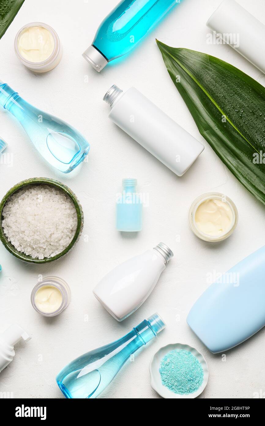 Different cosmetic products and sea salt on light background Stock ...