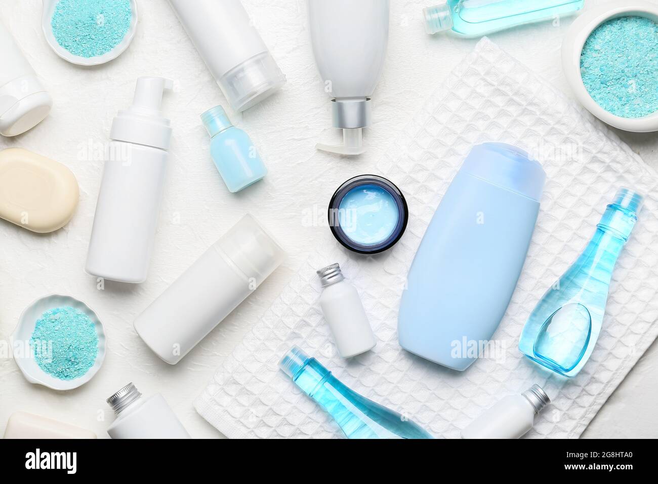 Different cosmetic products and towel on light background Stock Photo ...