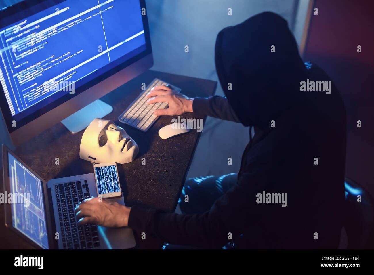 Hacker using computers in dark room Stock Photo - Alamy