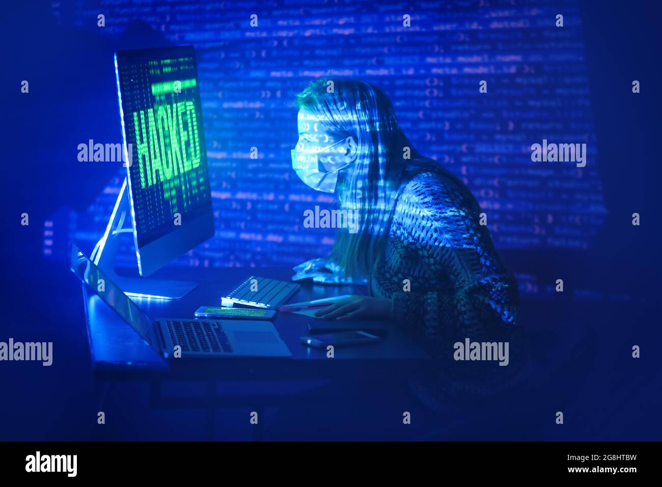 Woman sitting near hacked computer in dark room Stock Photo - Alamy