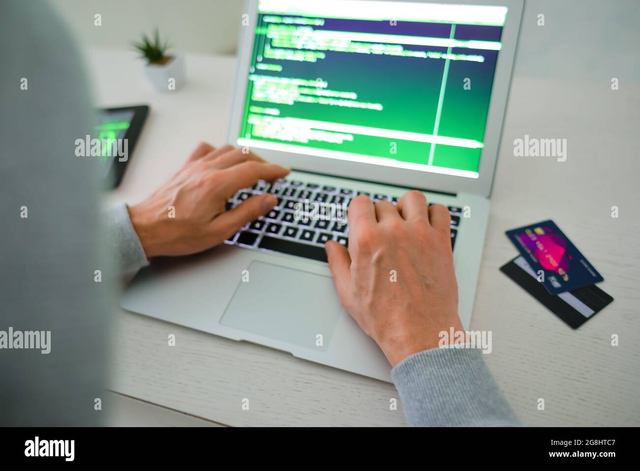 Hacker using computer at table Stock Photo - Alamy