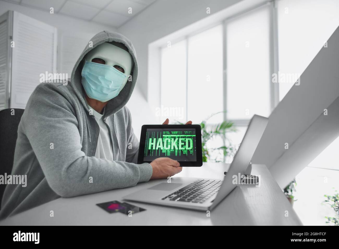 Hacker using computers in room Stock Photo - Alamy