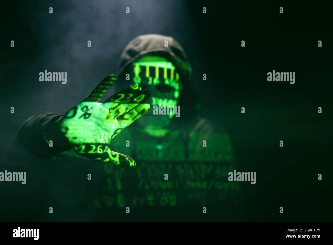 Hacker hiding his face on dark background Stock Photo - Alamy