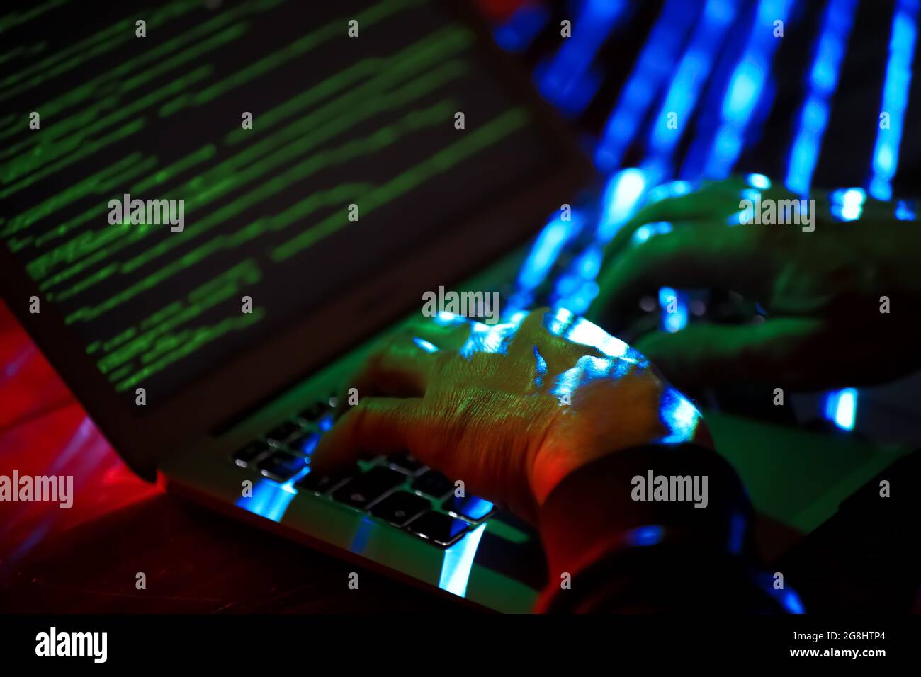 Hacker using computer in dark room Stock Photo - Alamy