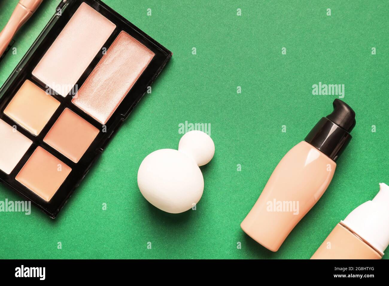 Makeup sponge with tonal foundation and blusher on color background ...