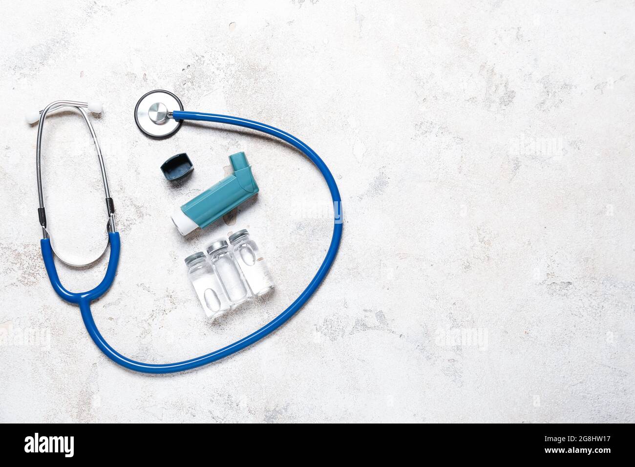 Modern inhaler, ampules and stethoscope on light background Stock Photo ...