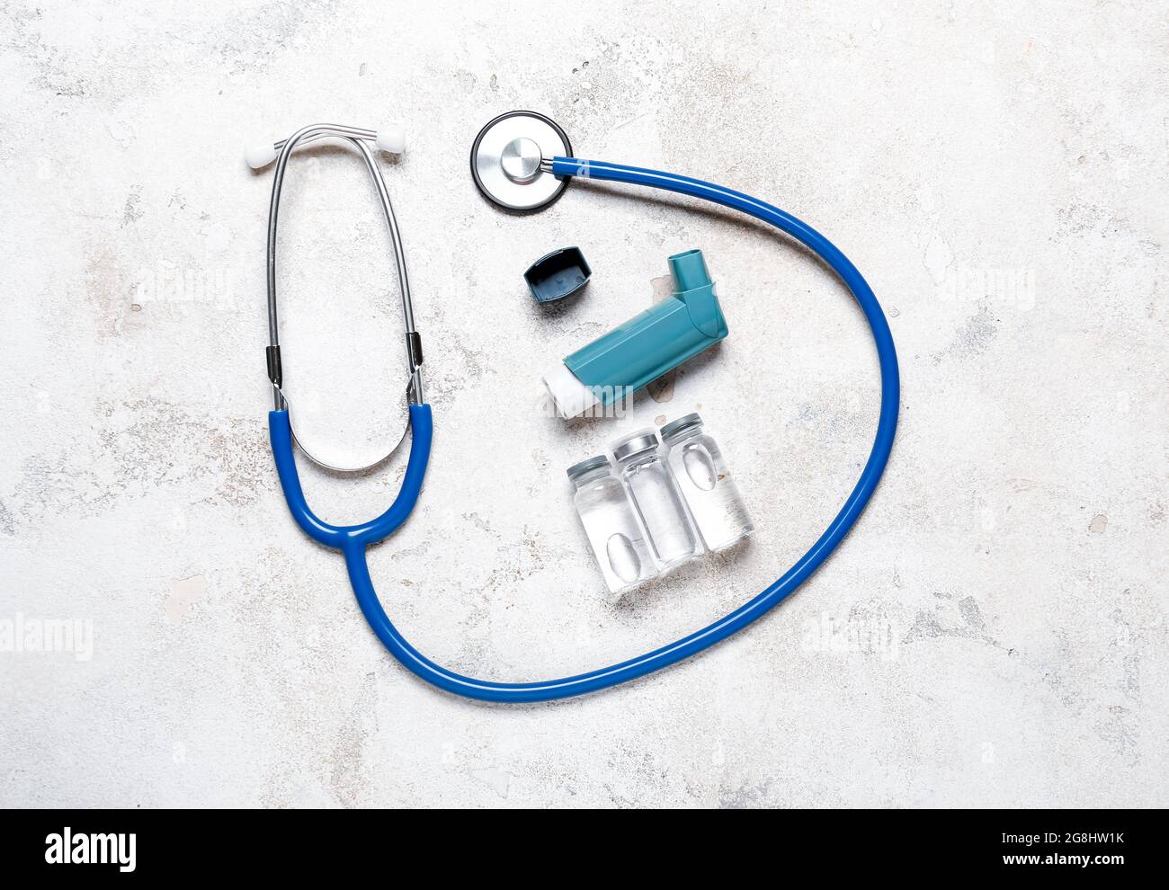 Modern inhaler, ampules and stethoscope on light background Stock Photo ...