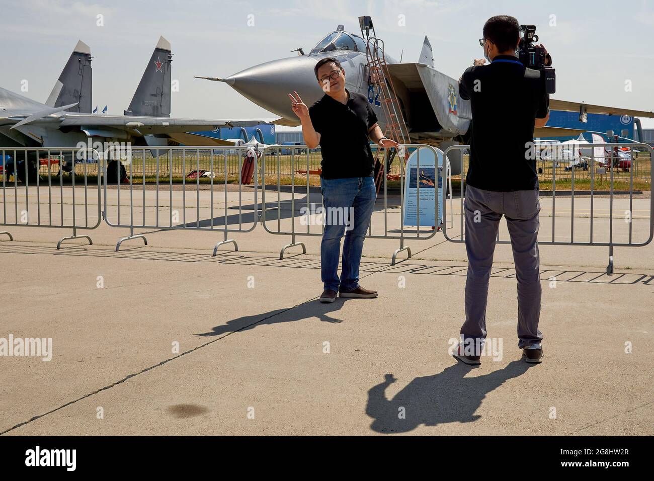 Chinese CCTV reporter posing with aircraft in the background, during ...