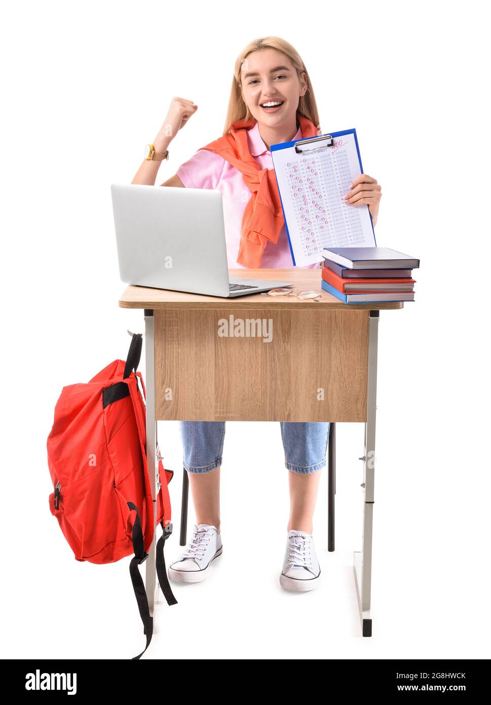 Happy student with answer sheet for school test at desk on white ...
