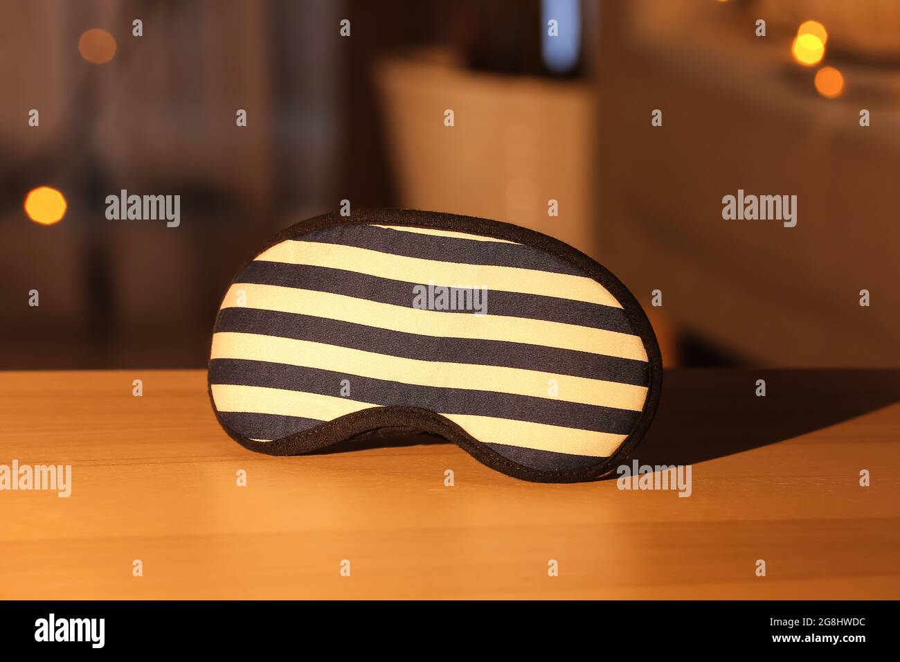 Stylish sleeping mask on table in dark room Stock Photo - Alamy
