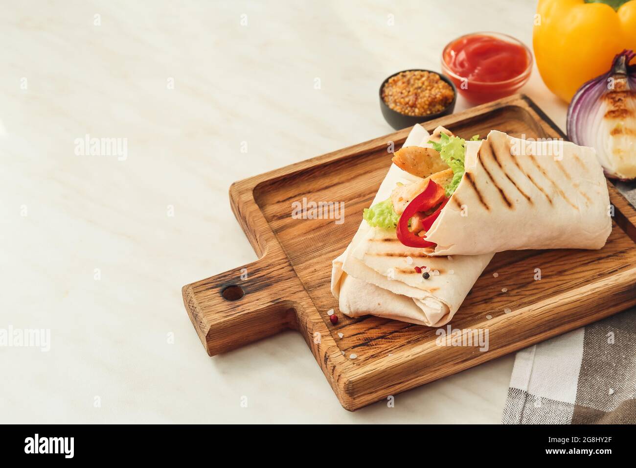 Board with tasty doner kebab and sauces on light background Stock Photo ...