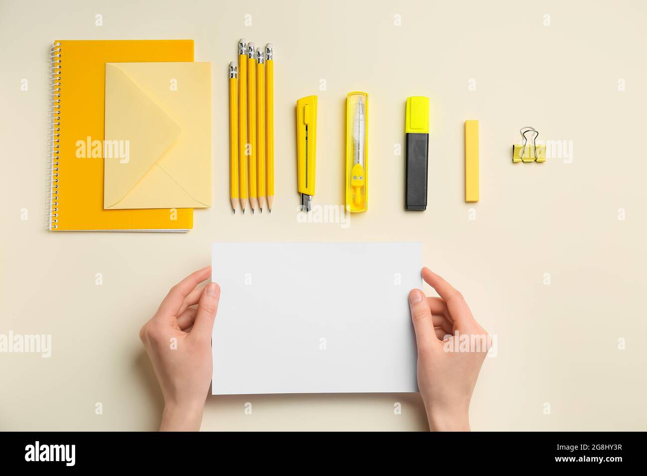 Female hands with blank sheet of paper and stationery on color ...
