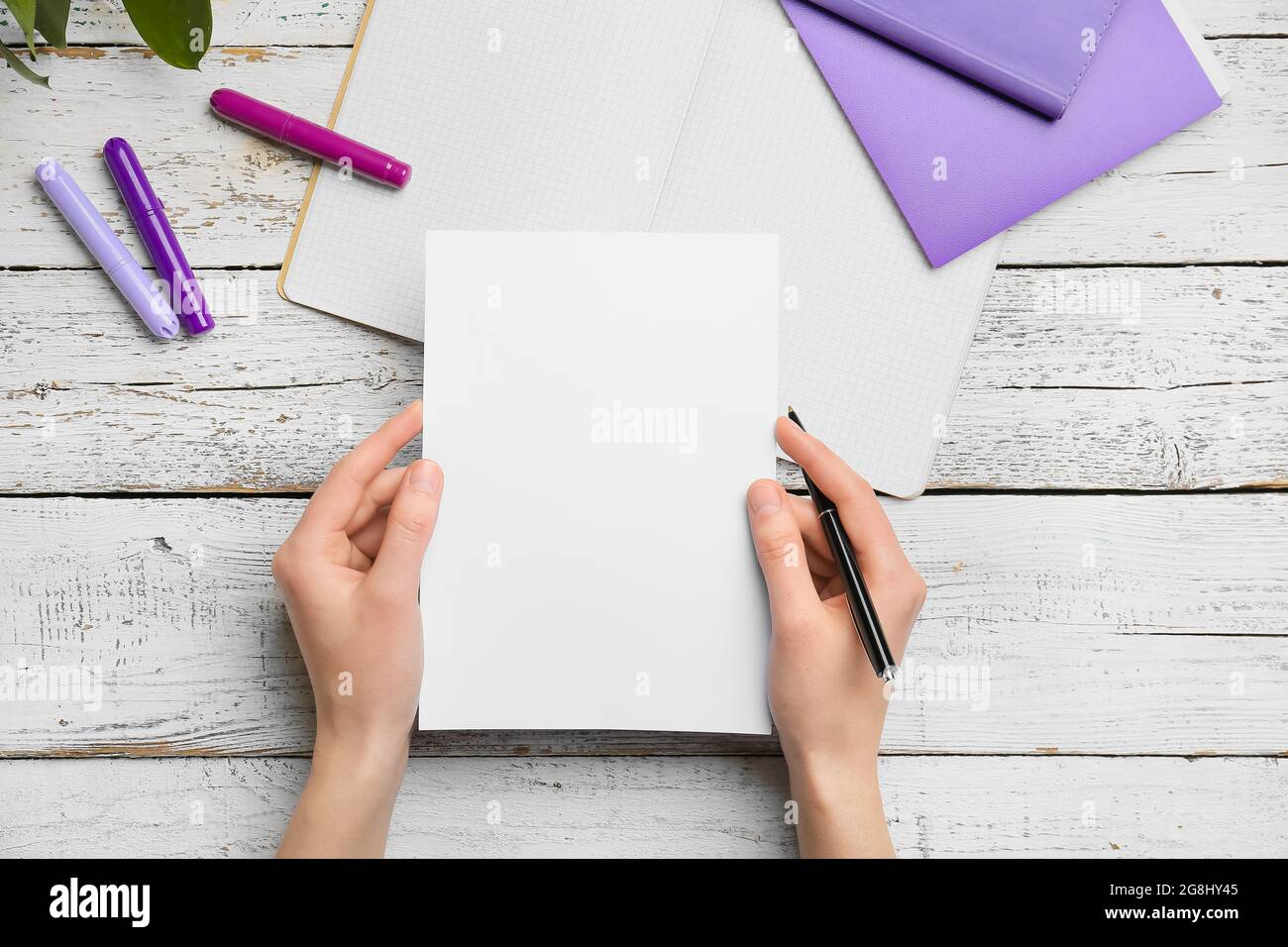 Female hands with blank sheet of paper and stationery on light wooden ...