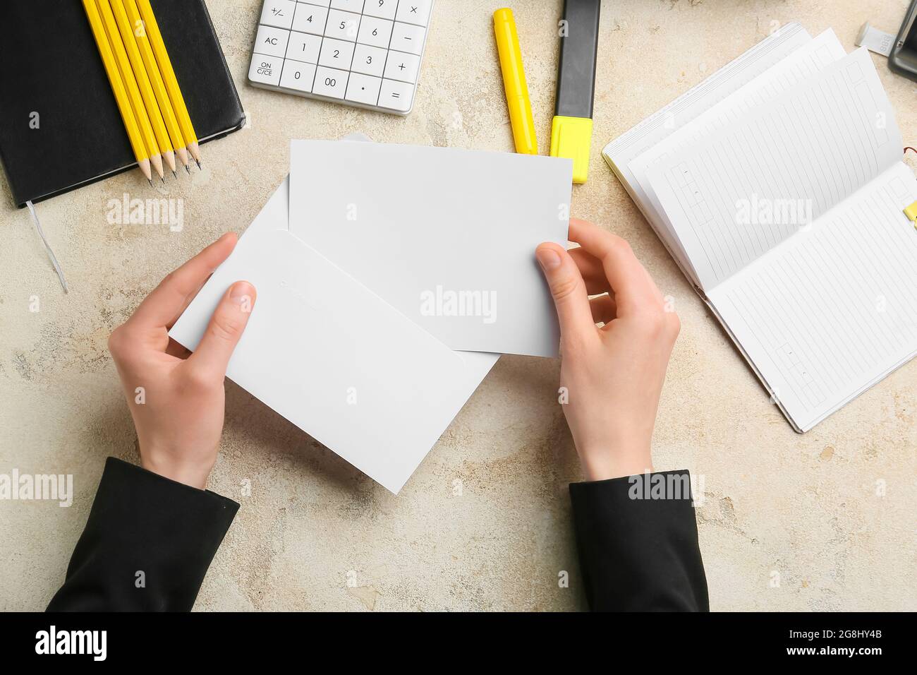 Female hands with blank sheet of paper, envelope and stationery on ...