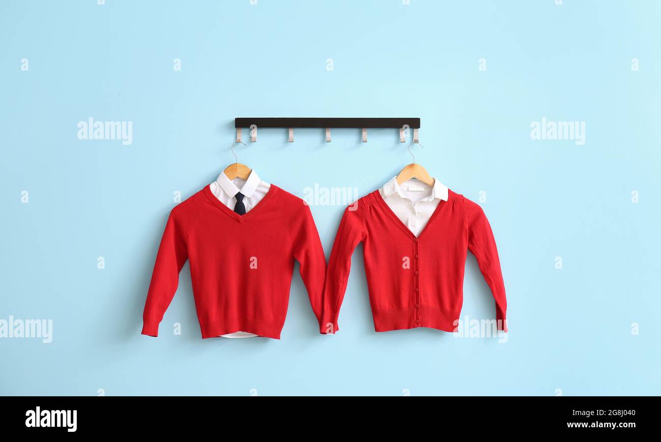 Modern school uniform hanging on color wall Stock Photo - Alamy