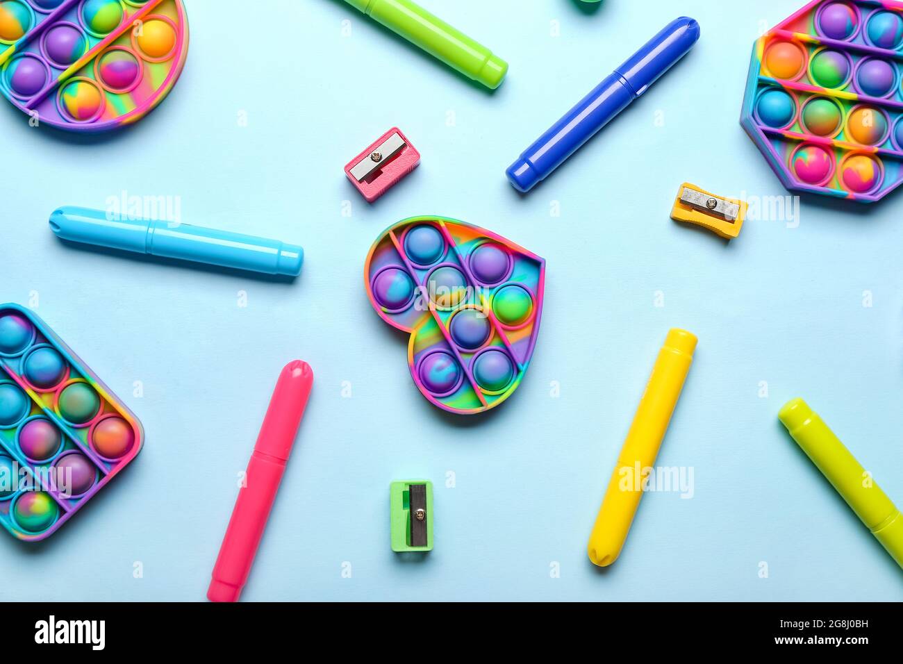 Pop it fidget toys and stationery on color background Stock Photo - Alamy