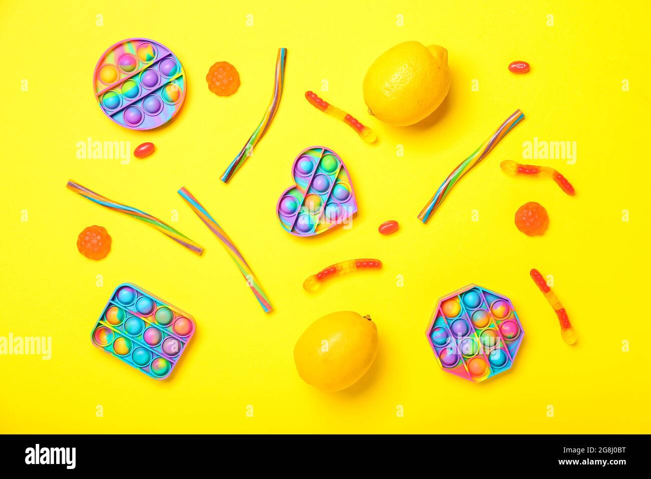 Pop it fidget toys, sweets and lemon on color background Stock Photo ...