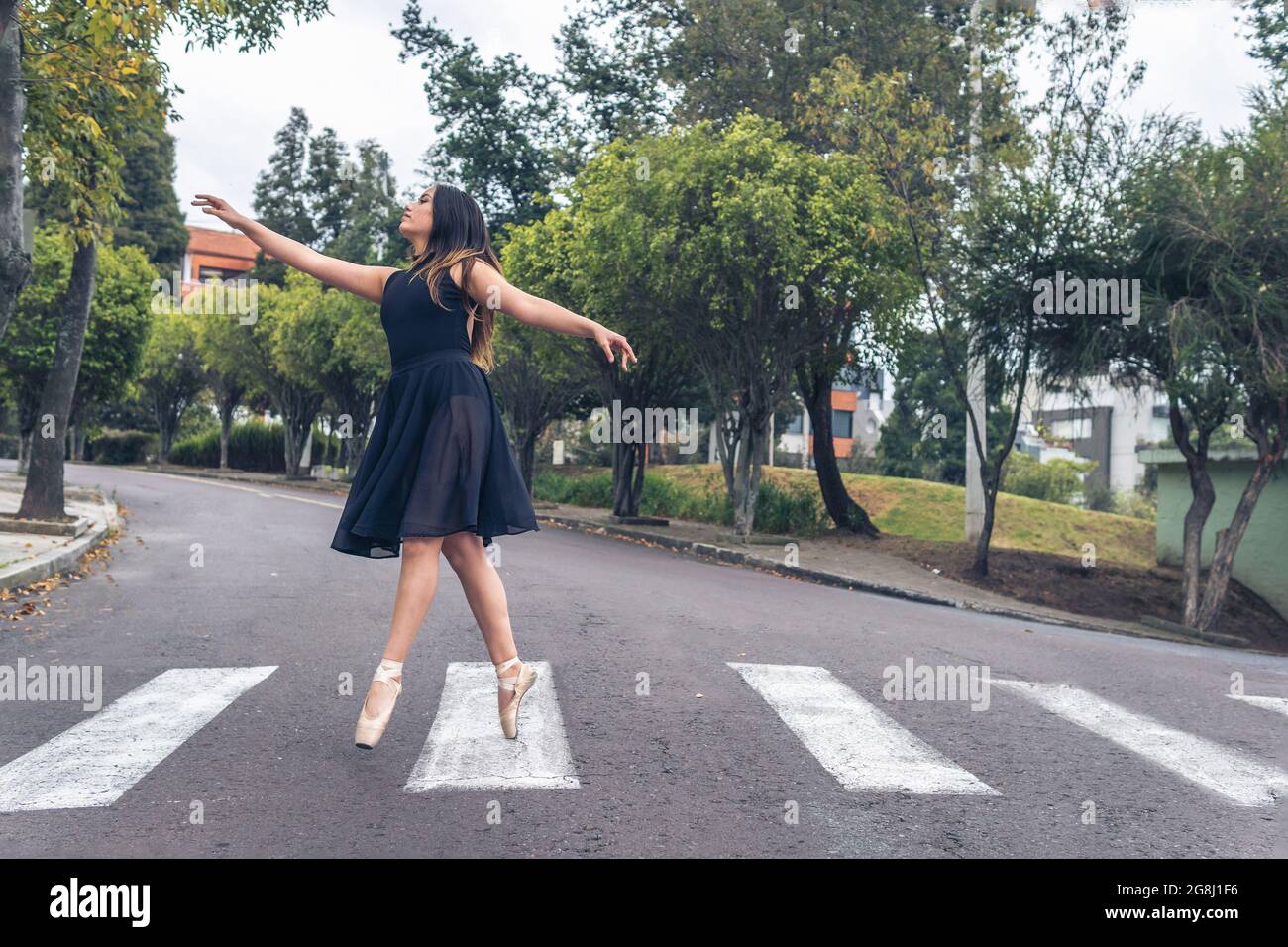Latin teenage dancer girl with black dress walking elegantly with ...