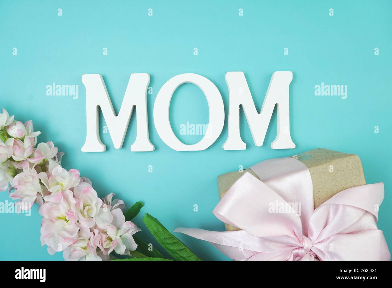 MOM alphabet letter with red flower and gift present on blue background ...