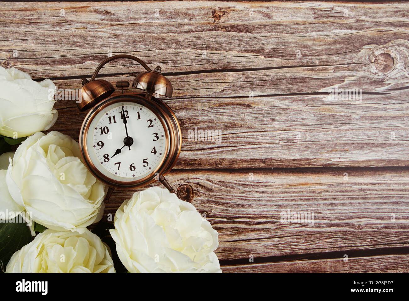 Alarm clock with Pink roses flowers border frame on wooden background ...