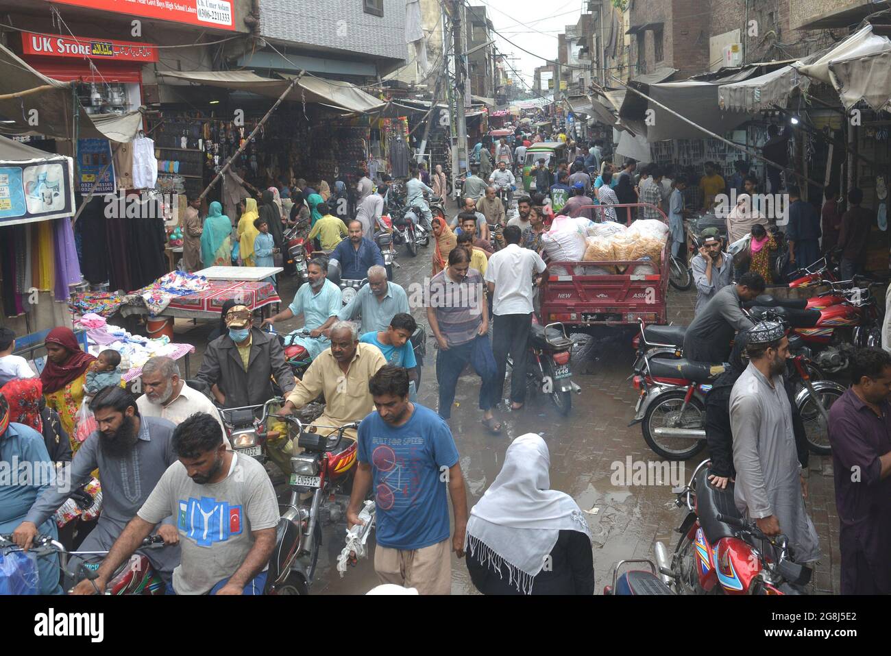 Lahore, Pakistan. 20th July, 2021. Pakistani commuters wade through a ...