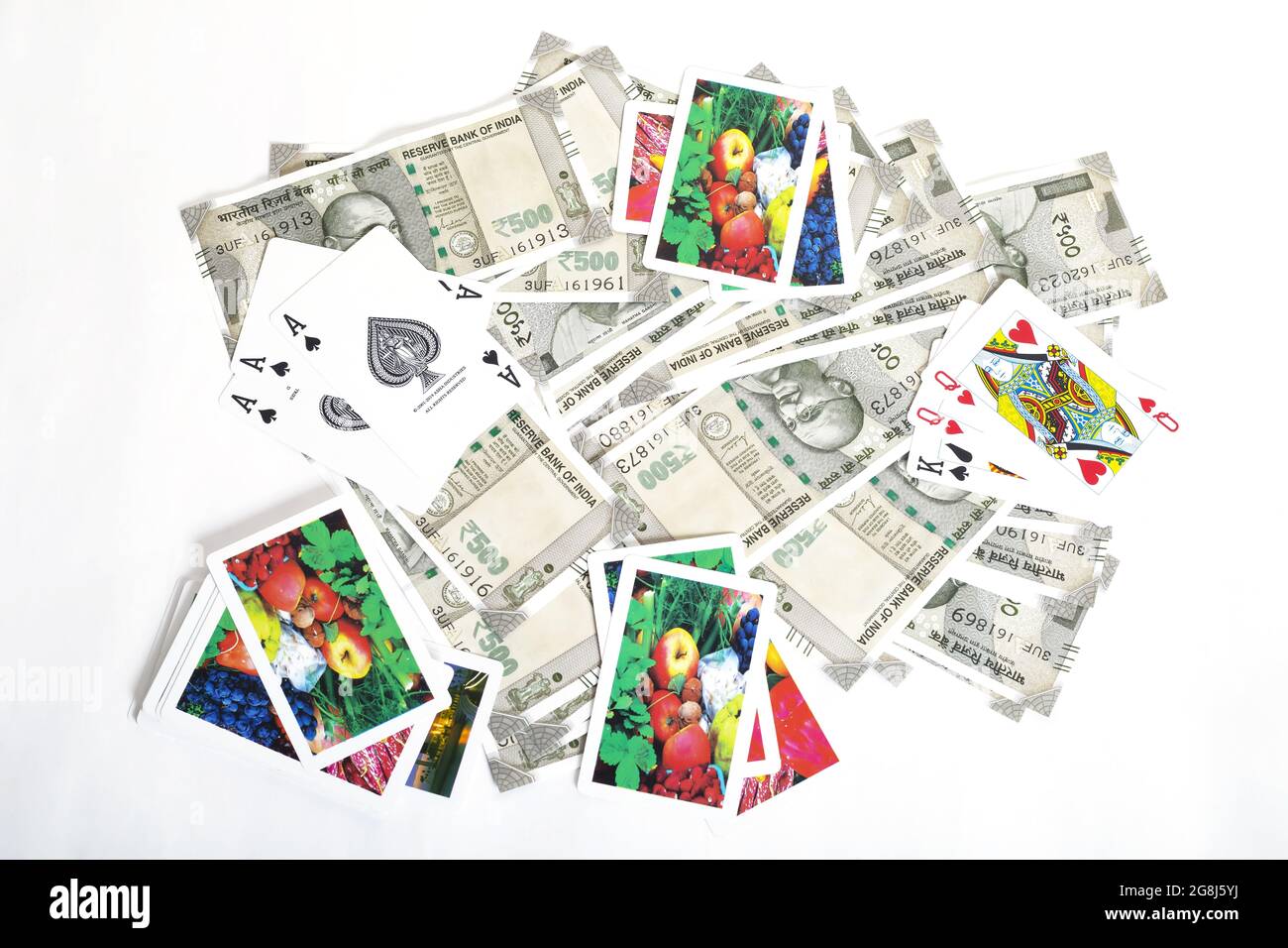 Pile of Indian rupees with poker cards on them on a white isolated ...