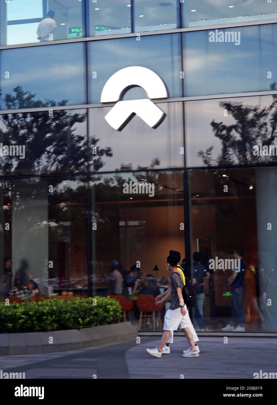 People walk past a NIO flagship store in Shanghai, China, 17 July 2021 ...