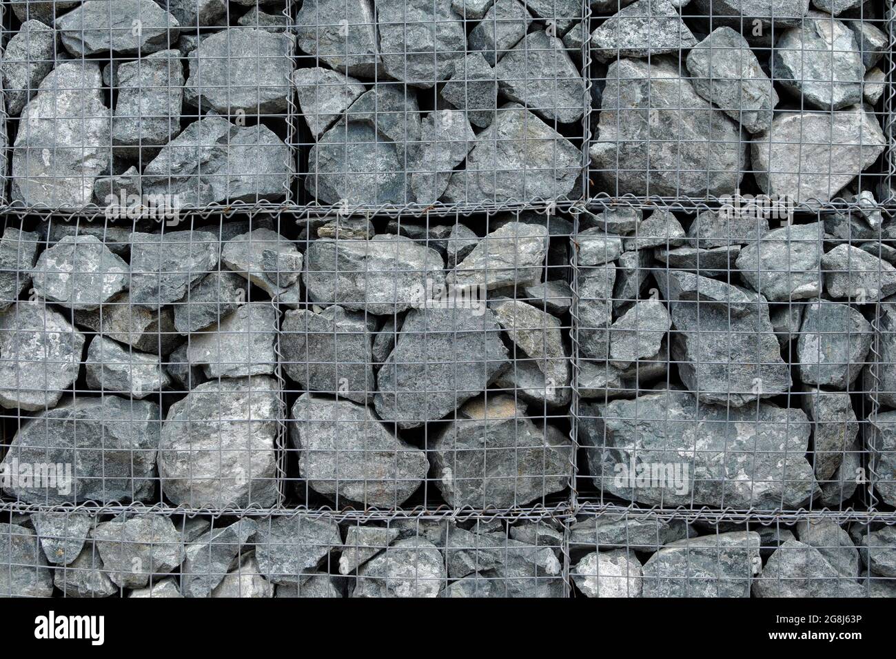 The texture of a fence made of many gray stones, reinforced with a ...