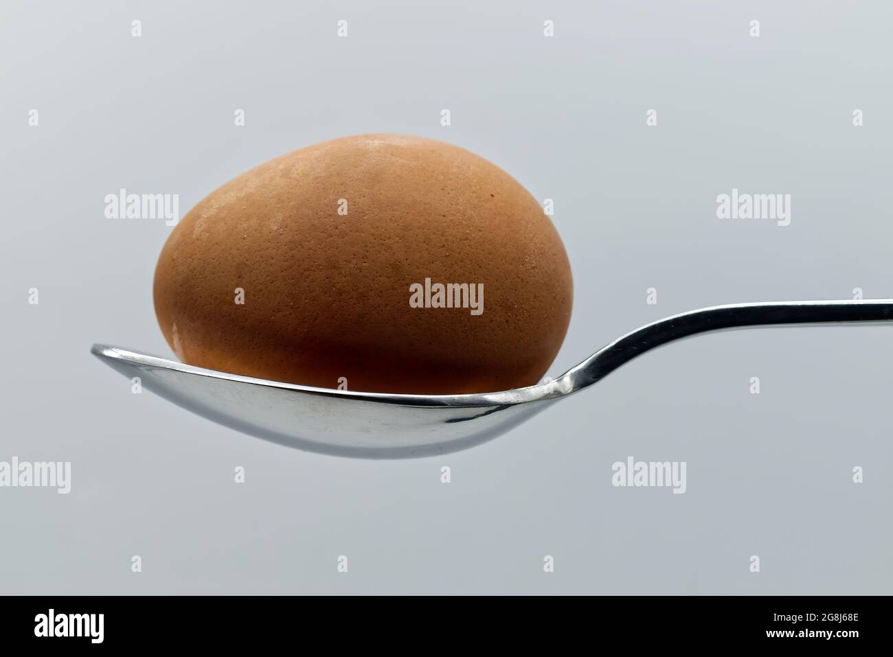 Egg in a spoon isolated on white background Stock Photo - Alamy