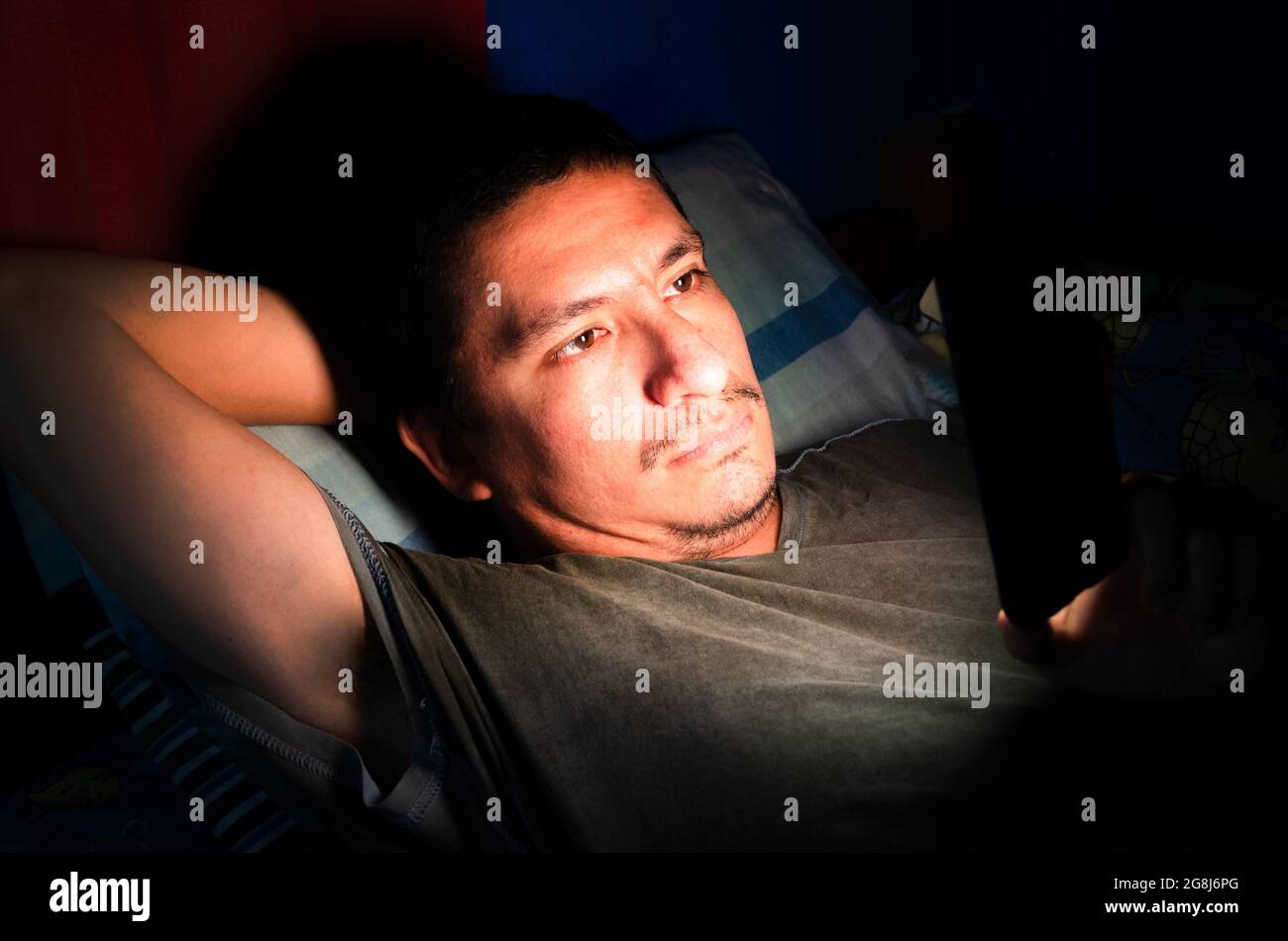 Man using his mobile phone in the bed Stock Photo - Alamy