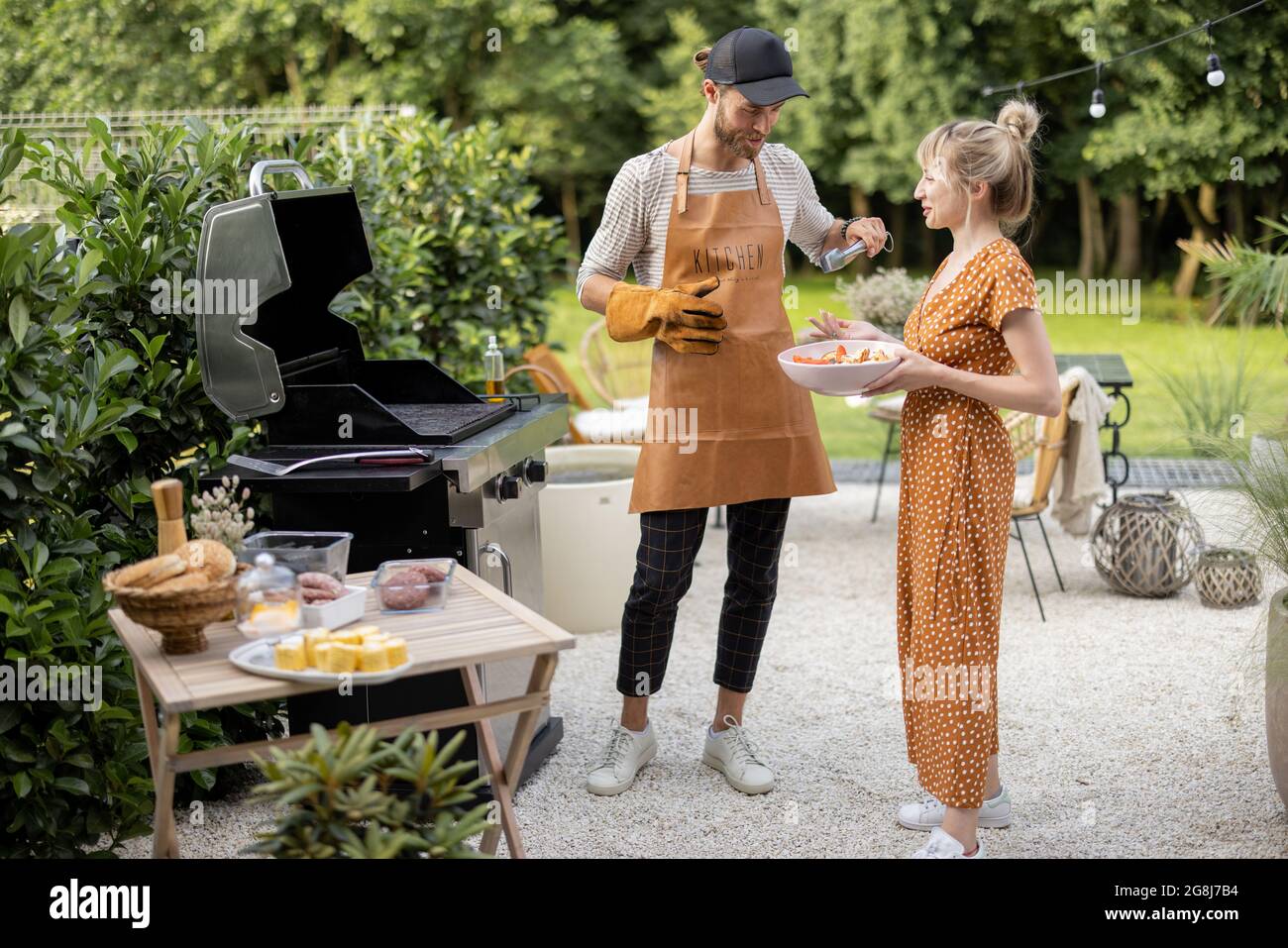 Couple grilling food at backyard Stock Photo - Alamy