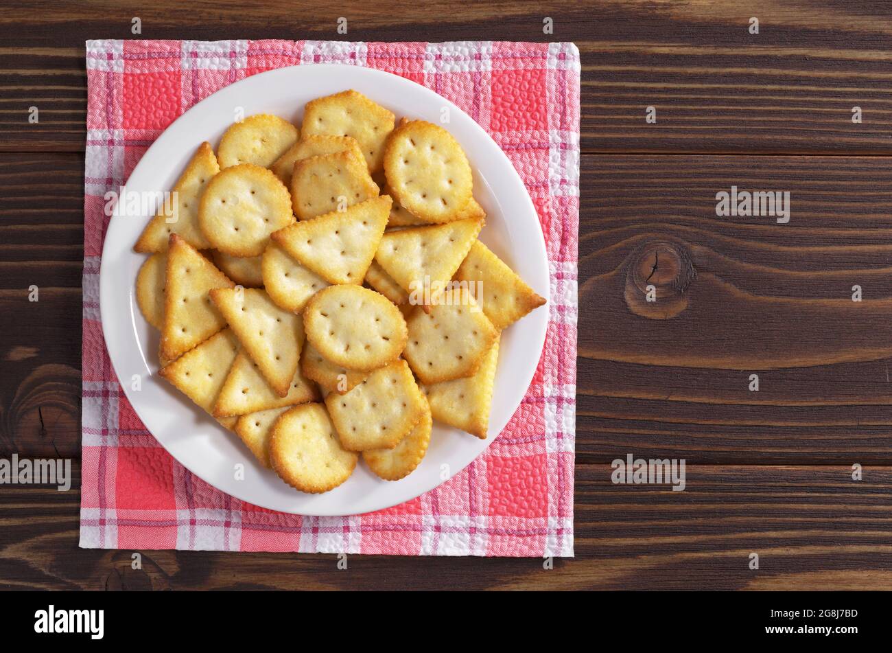 Crackers biscuits with cheese flavor in plate on wooden table, top view ...
