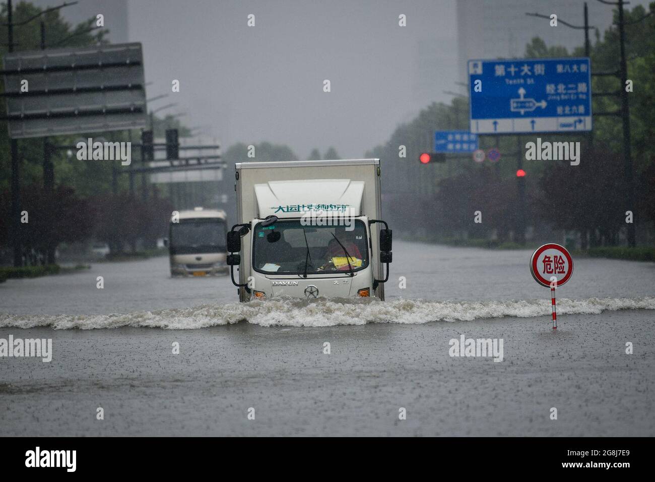 View of vehicles driving through city flood caused by continuous ...
