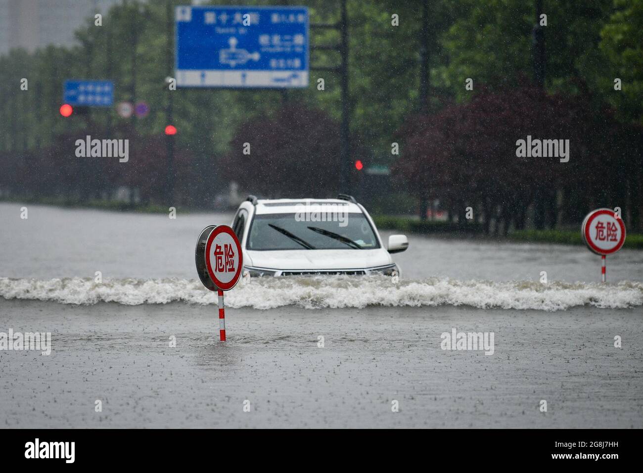 View of vehicles driving through city flood caused by continuous ...