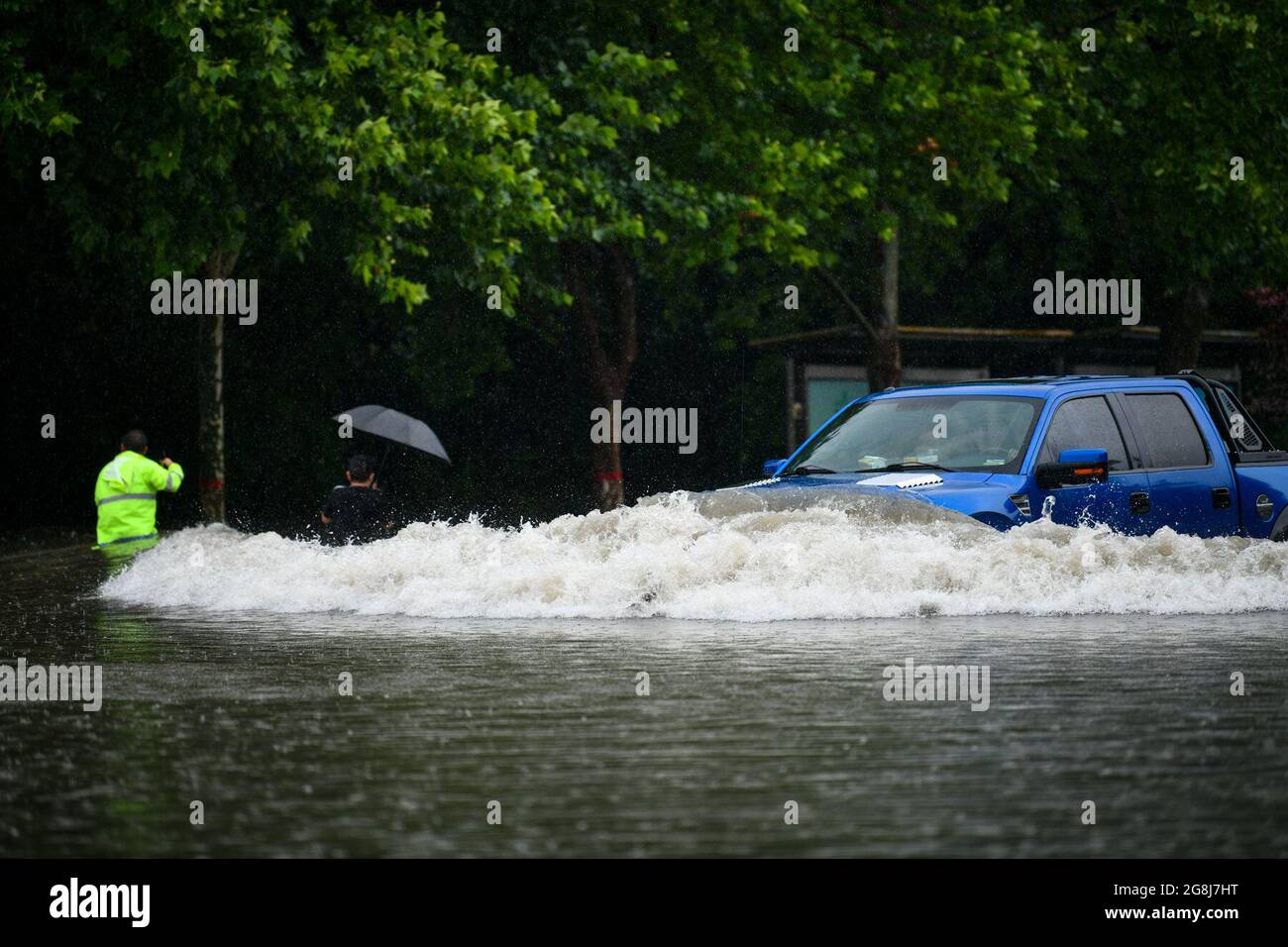 View of vehicles driving through city flood caused by continuous ...