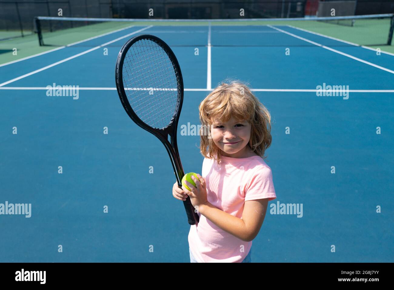 Funny kid tennis player on tennis court. Child boy with tennis racket ...