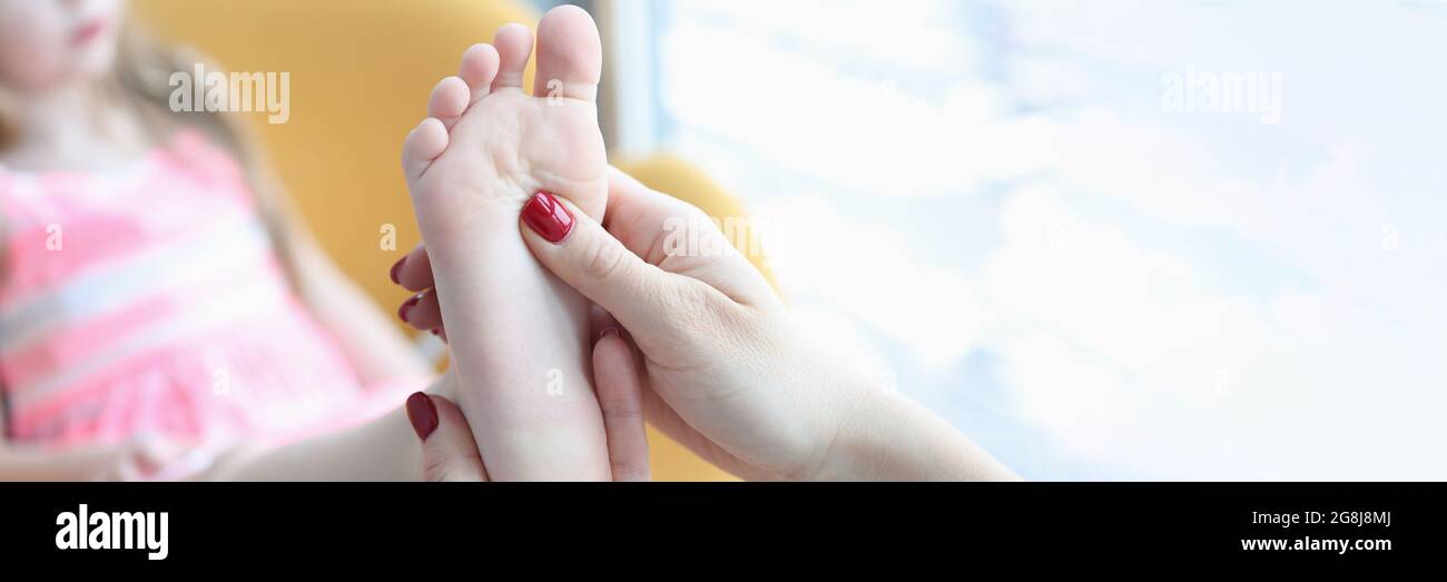 Doctor orthopedist examining feet of little girl closeup. Correction of ...