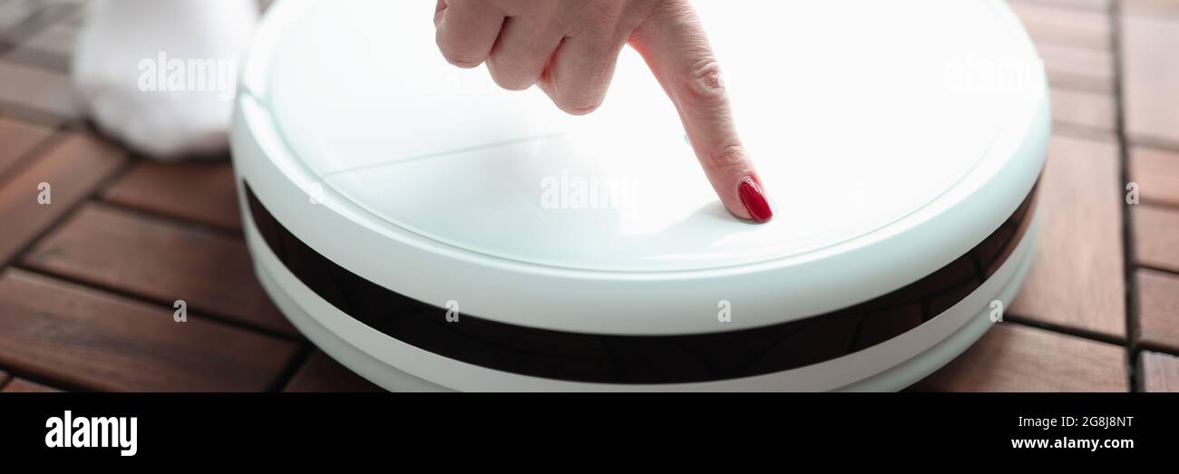 Woman turning on finger of robot vacuum cleaner closeup. Sale of ...