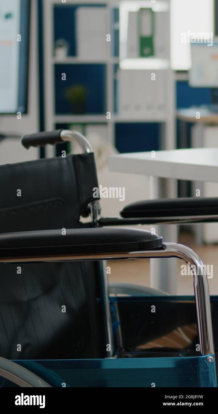 Wheelchair parked in empty office room near desk in start up financial ...