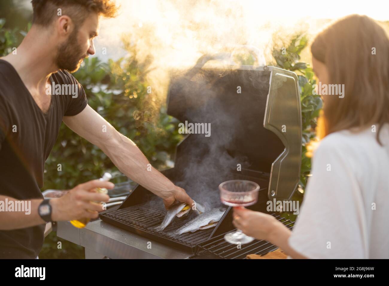 Man cooking fish on a grill Stock Photo - Alamy