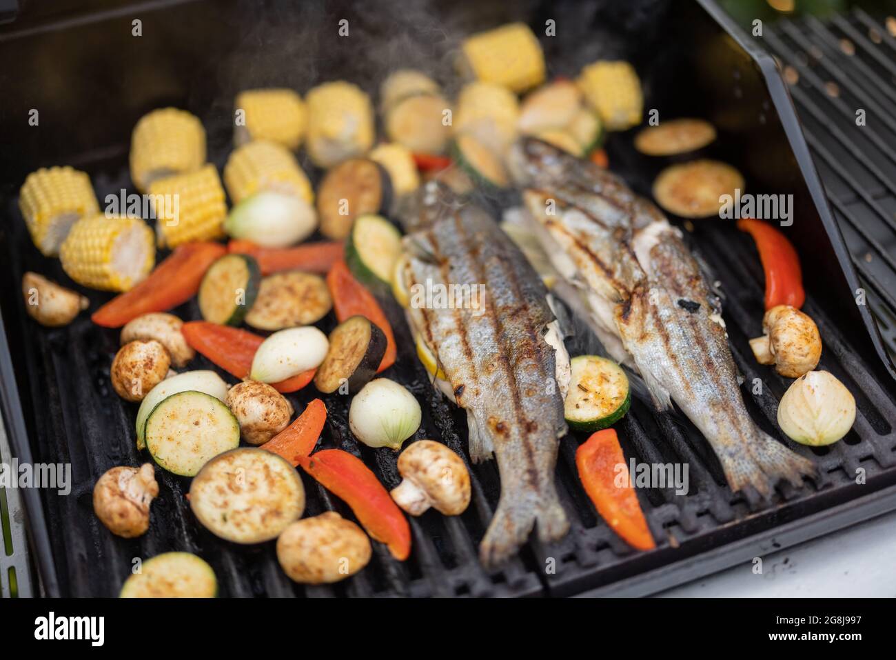 Fish and vegetables on a grill Stock Photo - Alamy