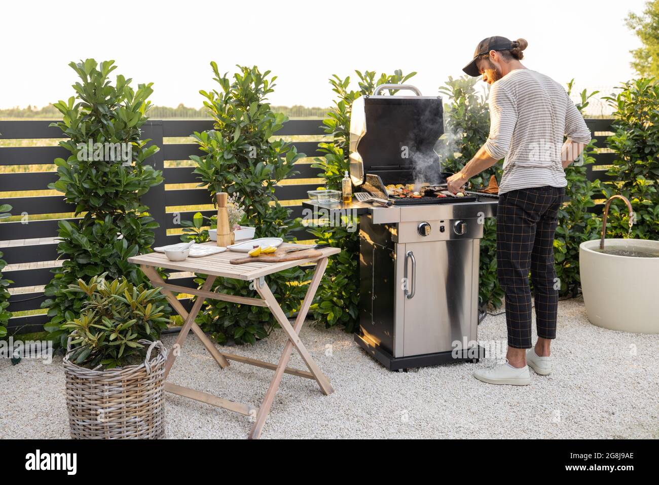 Man cooking on a grill outdoors Stock Photo - Alamy