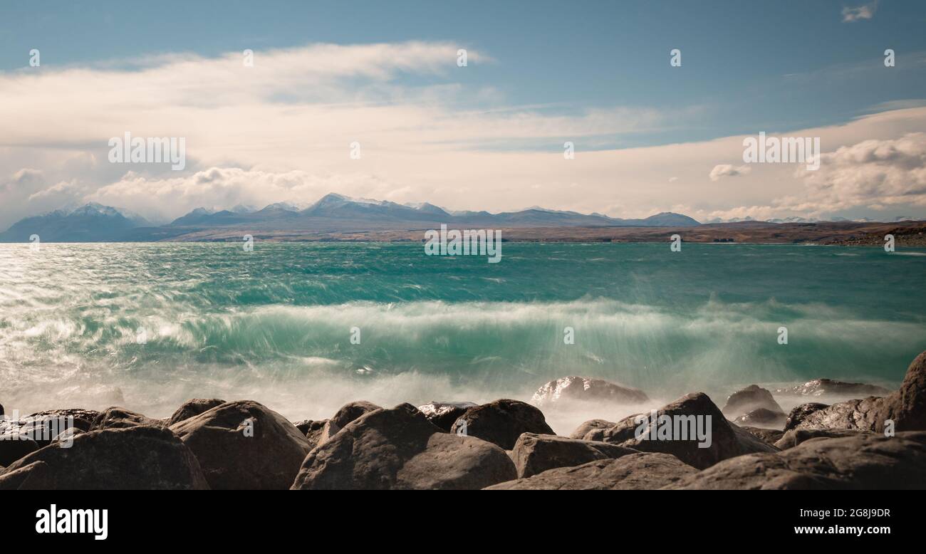Strong wind and crashing waves hitting the rocks at Lake Pukaki with ...