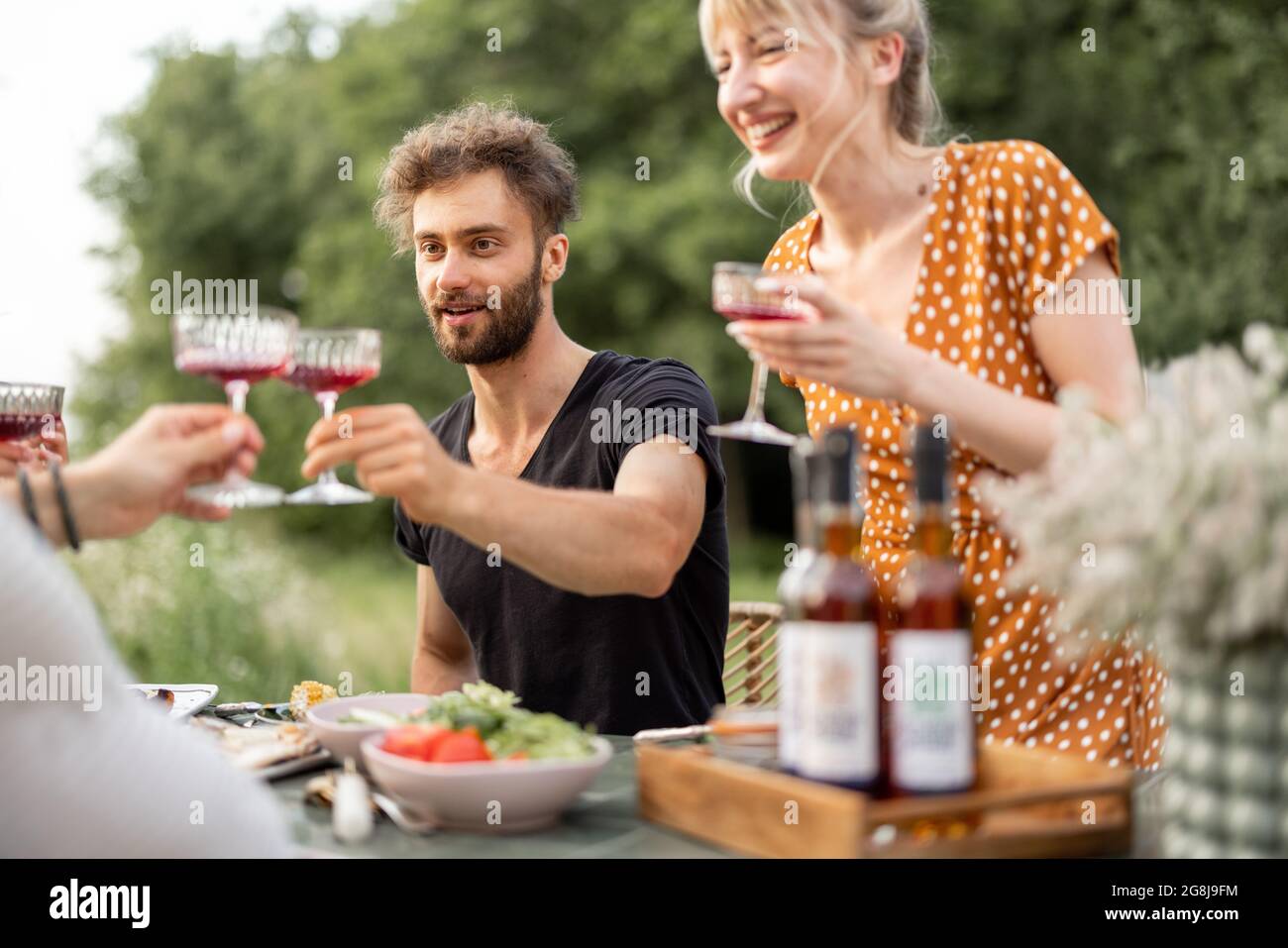 Friends drinking alcohol at festive dinner outdoors Stock Photo - Alamy